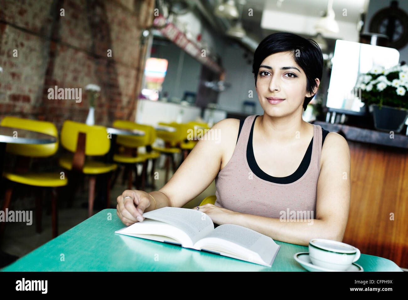 Woman with Book and Coffee in Restaurant Stock Photo - Alamy