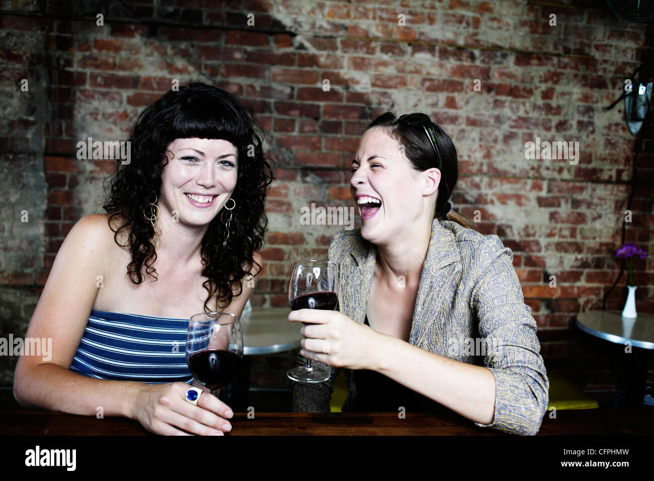 Female Friends Laughing Over Drinks Stock Photo - Alamy