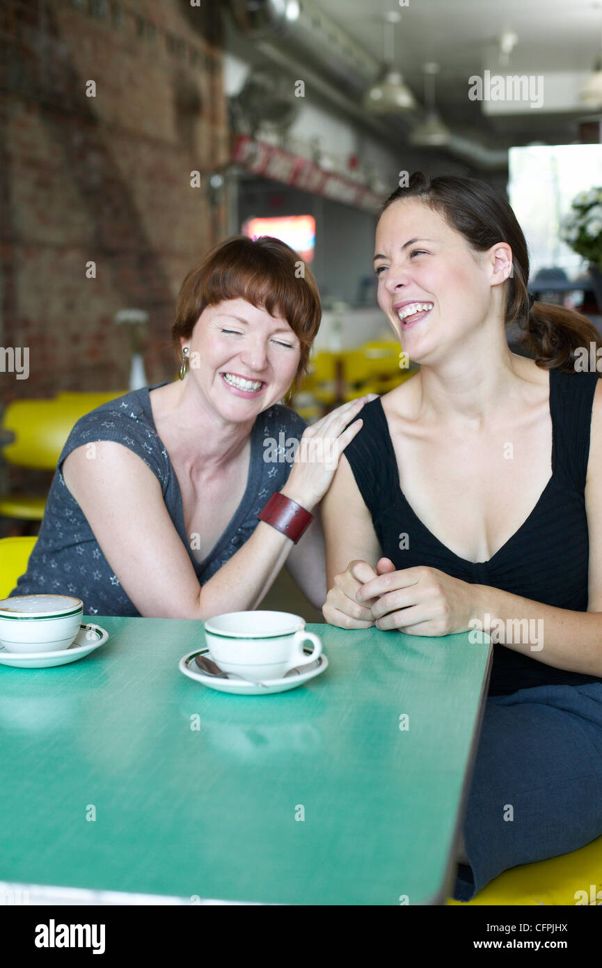 Female Friends Laughing over Coffee Stock Photo - Alamy