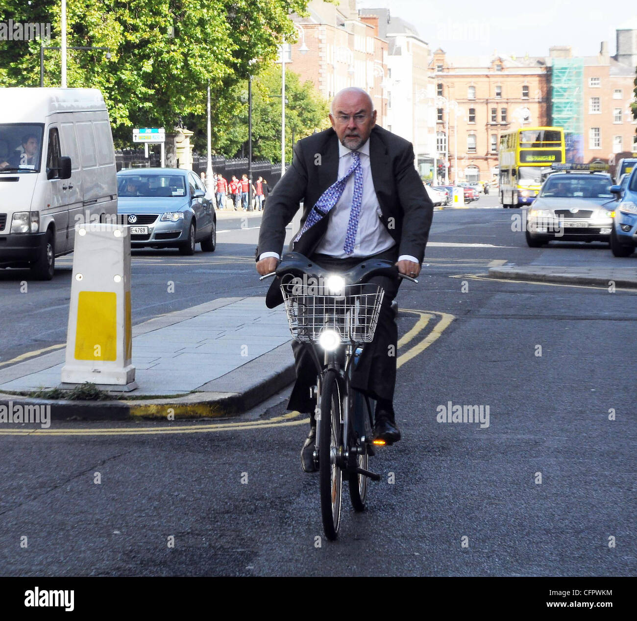 Minister Ruairi Quinn rides his bicycle outside the Merrion Hotel today ...