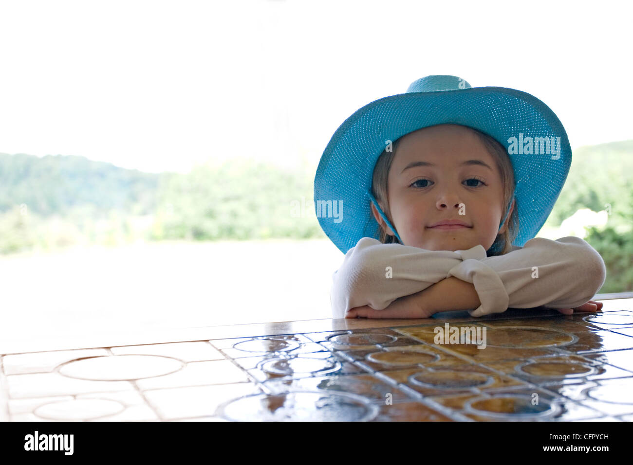 Young Girl Resting on Edge of Table Stock Photo - Alamy