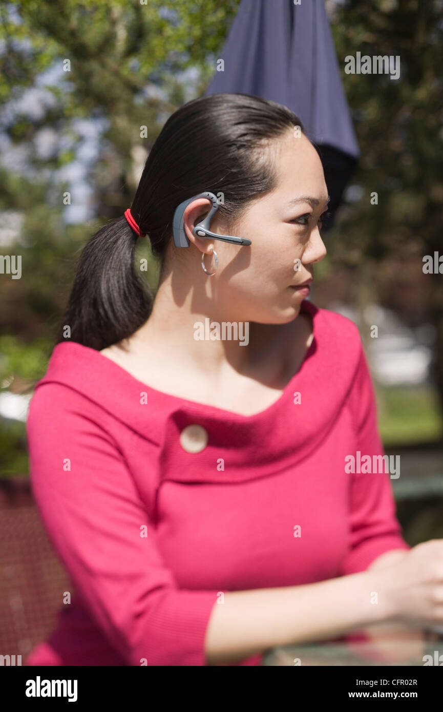 Asian Woman Wearing a Bluetooth Headset Stock Photo - Alamy