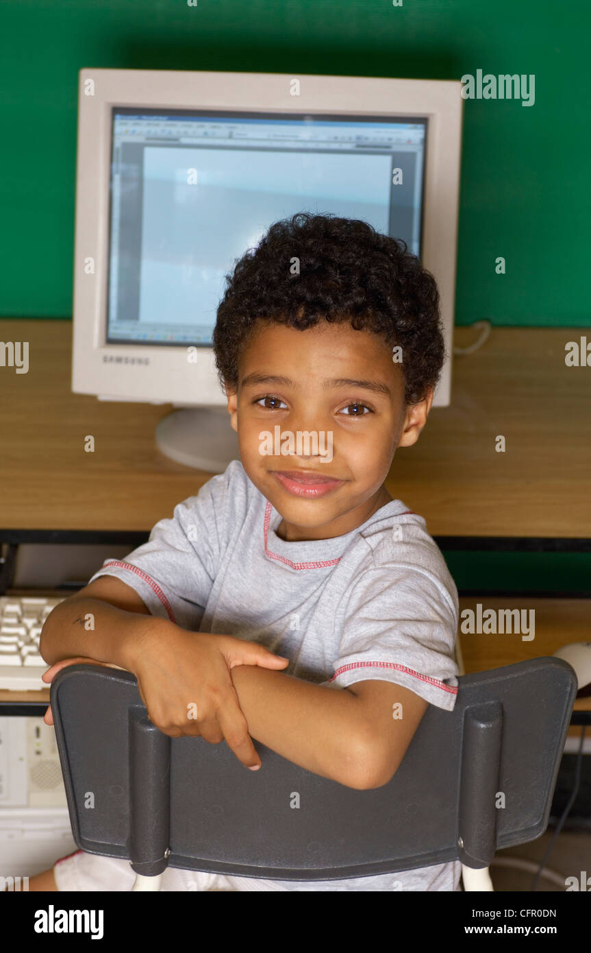 Boy Sitting at Desk with Computer Stock Photo - Alamy