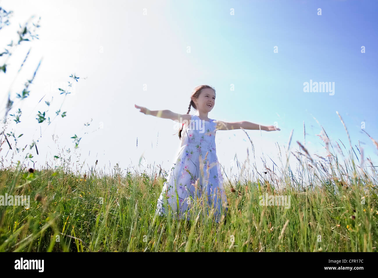 Girl in Field with Arms Stretched Out Stock Photo - Alamy
