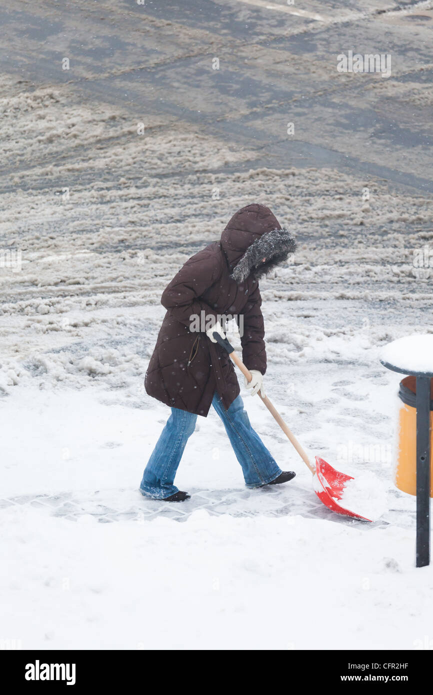 Woman shoveling snow Stock Photo - Alamy
