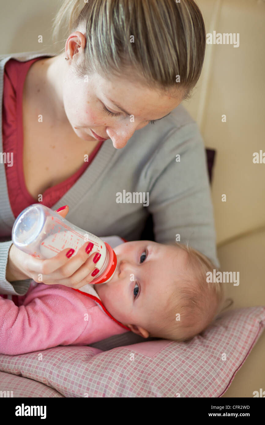 Mother feeding infant girl with baby formula Stock Photo - Alamy
