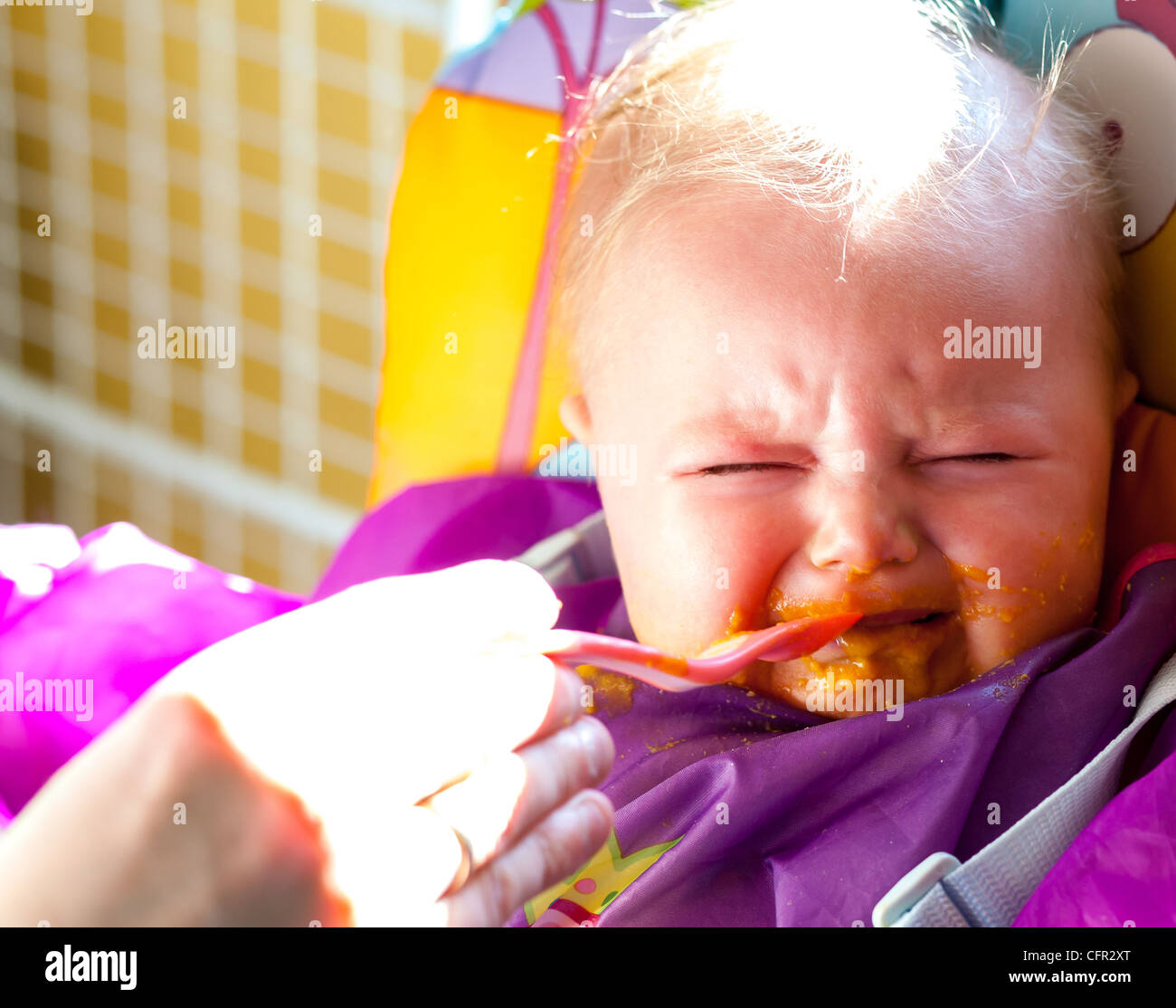 Teaching infant how to eat solid food Stock Photo - Alamy