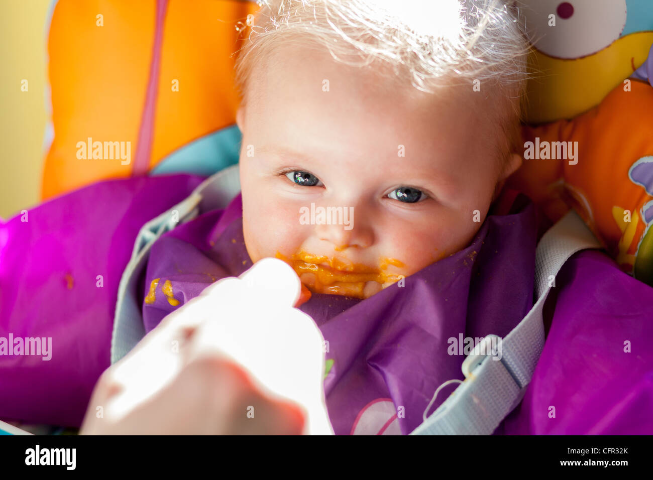 Teaching infant how to eat solid food Stock Photo - Alamy