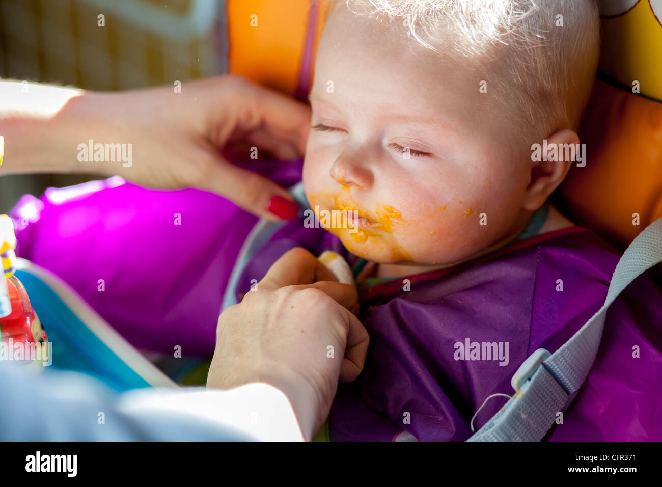 Teaching infant how to eat solid food Stock Photo - Alamy