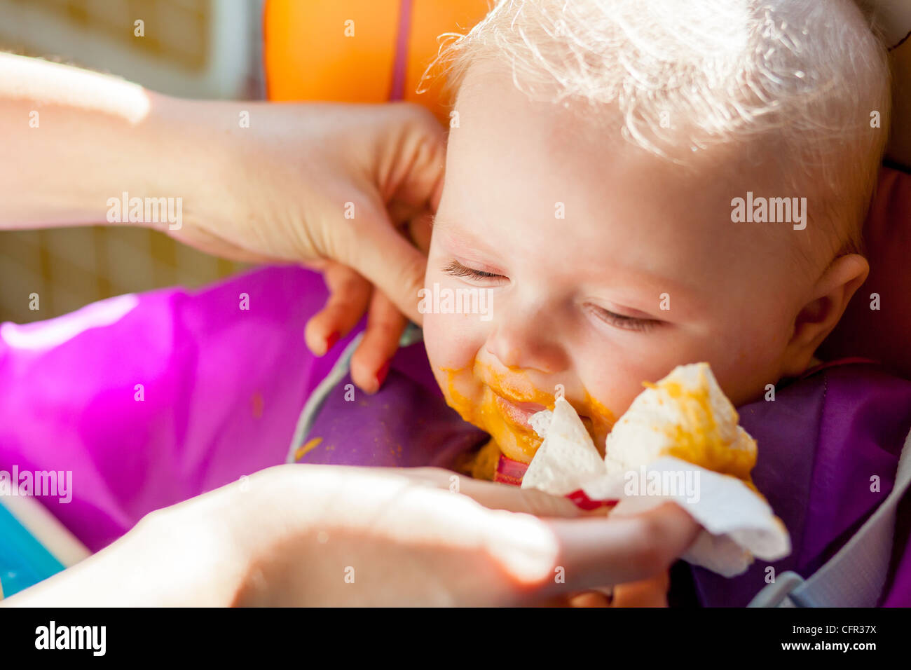 Teaching infant how to eat solid food Stock Photo - Alamy