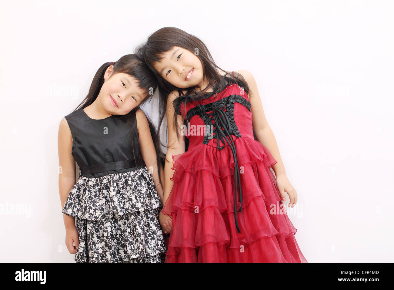 Two asian girls holding hands and smiling Stock Photo - Alamy