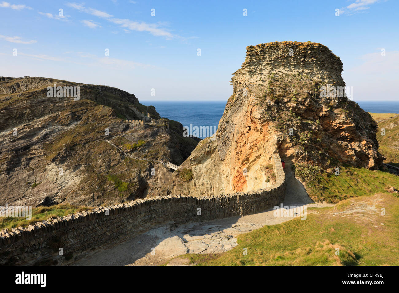 View over stone wall to King Arthur's Camelot Castle on rocky headland ...