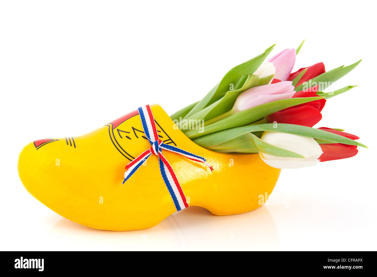 Yellow Dutch wooden clogs with colorful tulips Stock Photo - Alamy