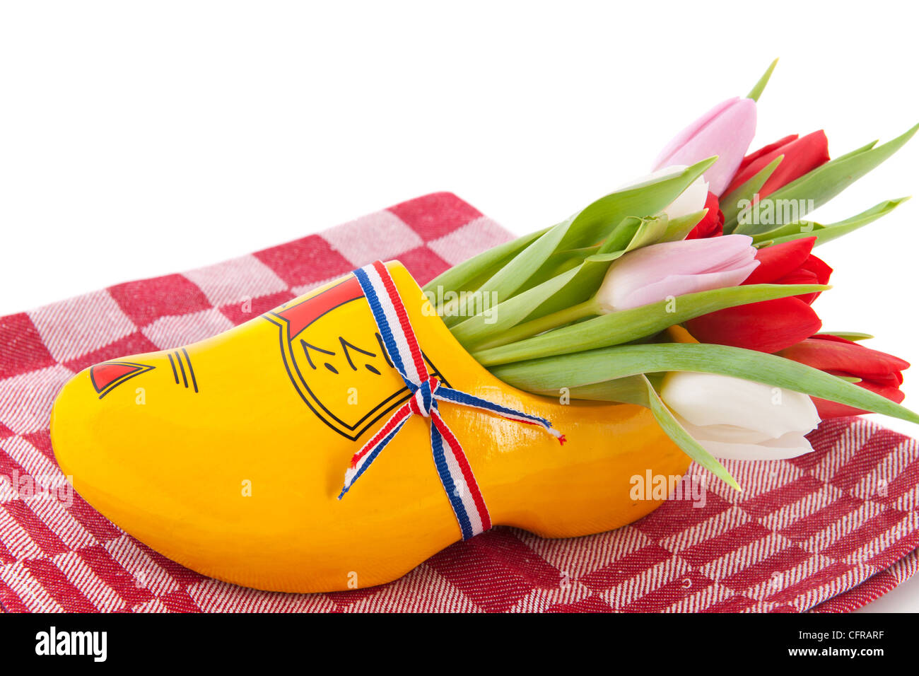Yellow Dutch wooden clogs with colorful tulips Stock Photo - Alamy