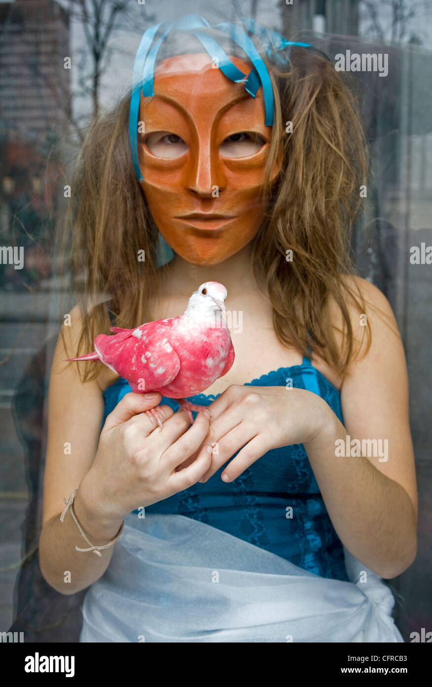 Girl in mask holding pink dove, Belfast City Center Stock Photo - Alamy
