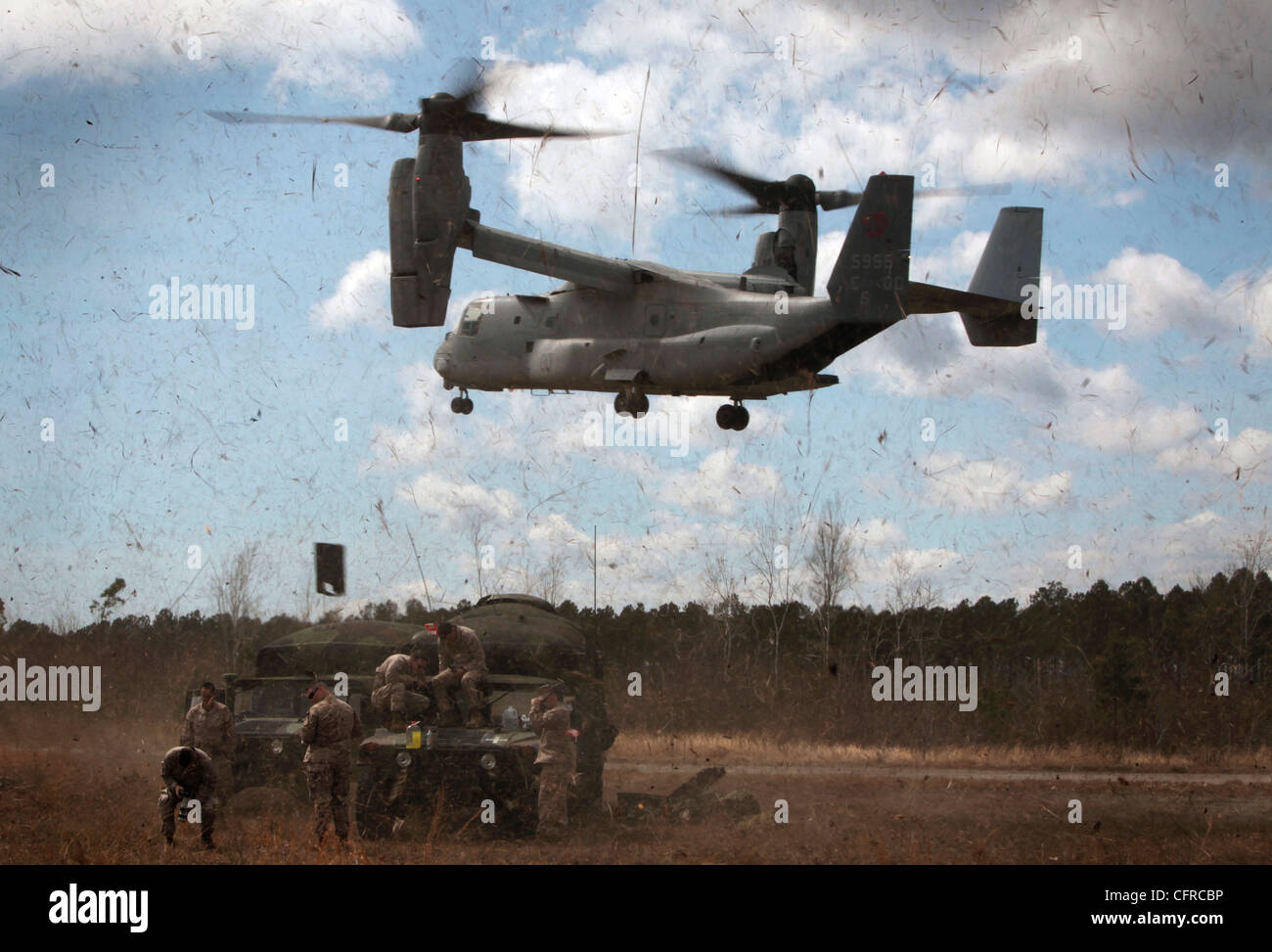 A MV-22 Osprey vertical lift aircraft kicks up debris as it prepares to ...