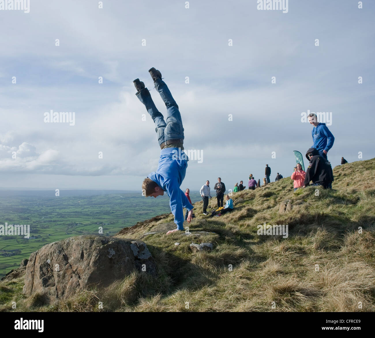 Young man doing somersault on summit of Slemish during St. Patrick's ...