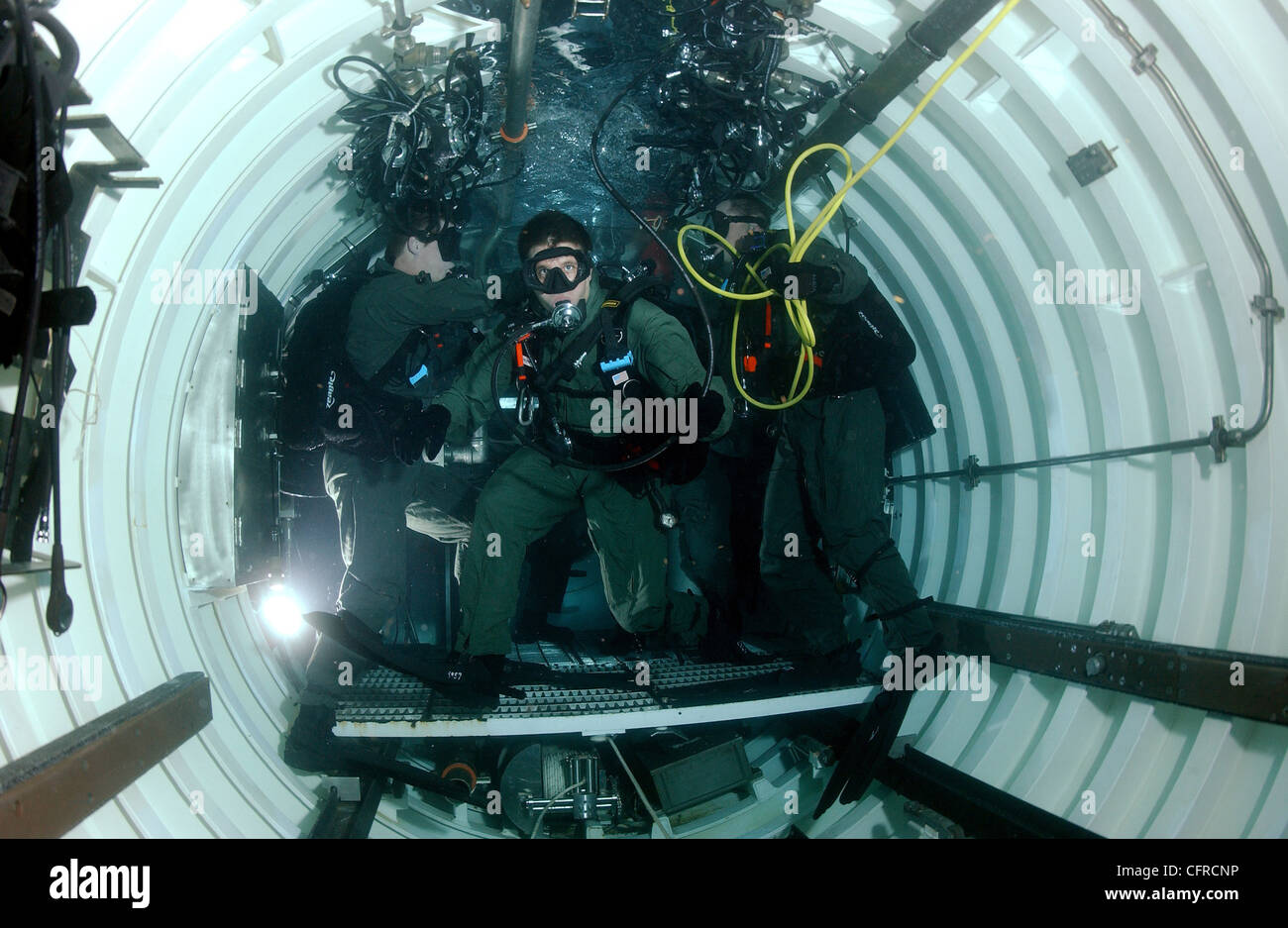 A members of SEAL Team Two huddle together inside a flooded Dry Deck ...