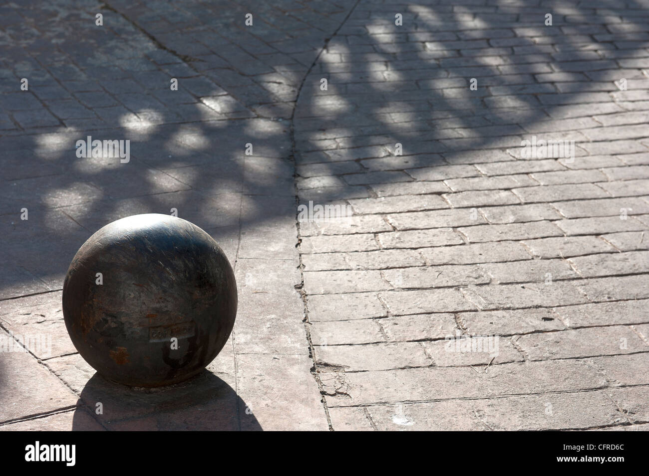 Stone ball on paving stones with shadow pattern of adjacent fence Stock ...