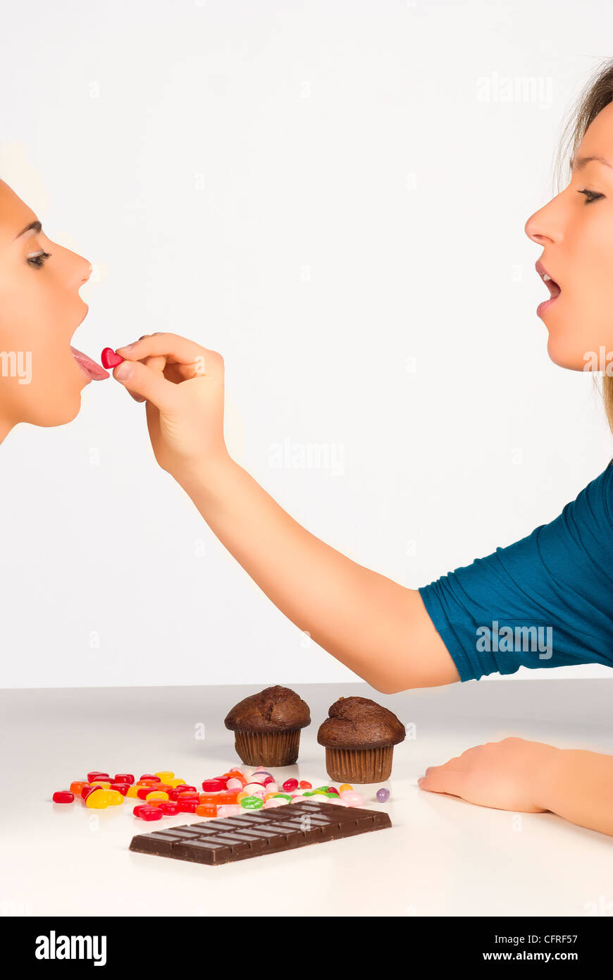 Friends feeding each other candy Stock Photo - Alamy