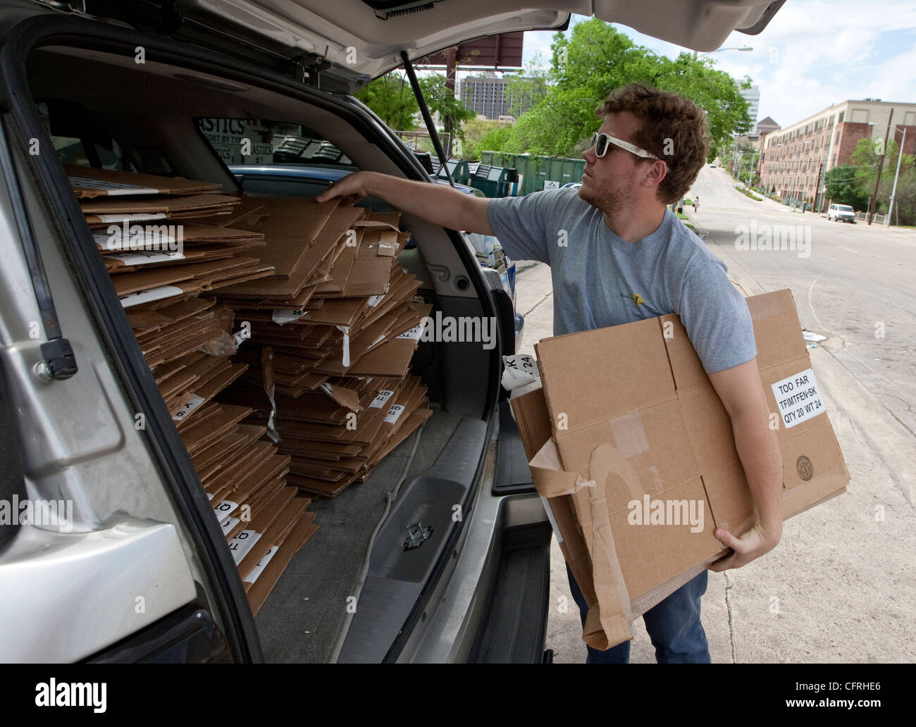 Young citizens bring in cardboard to a recycling drop-off and ...