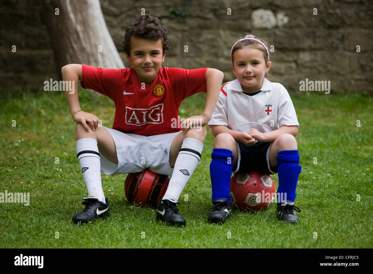Brother and sister football players in the front garden Stock Photo - Alamy