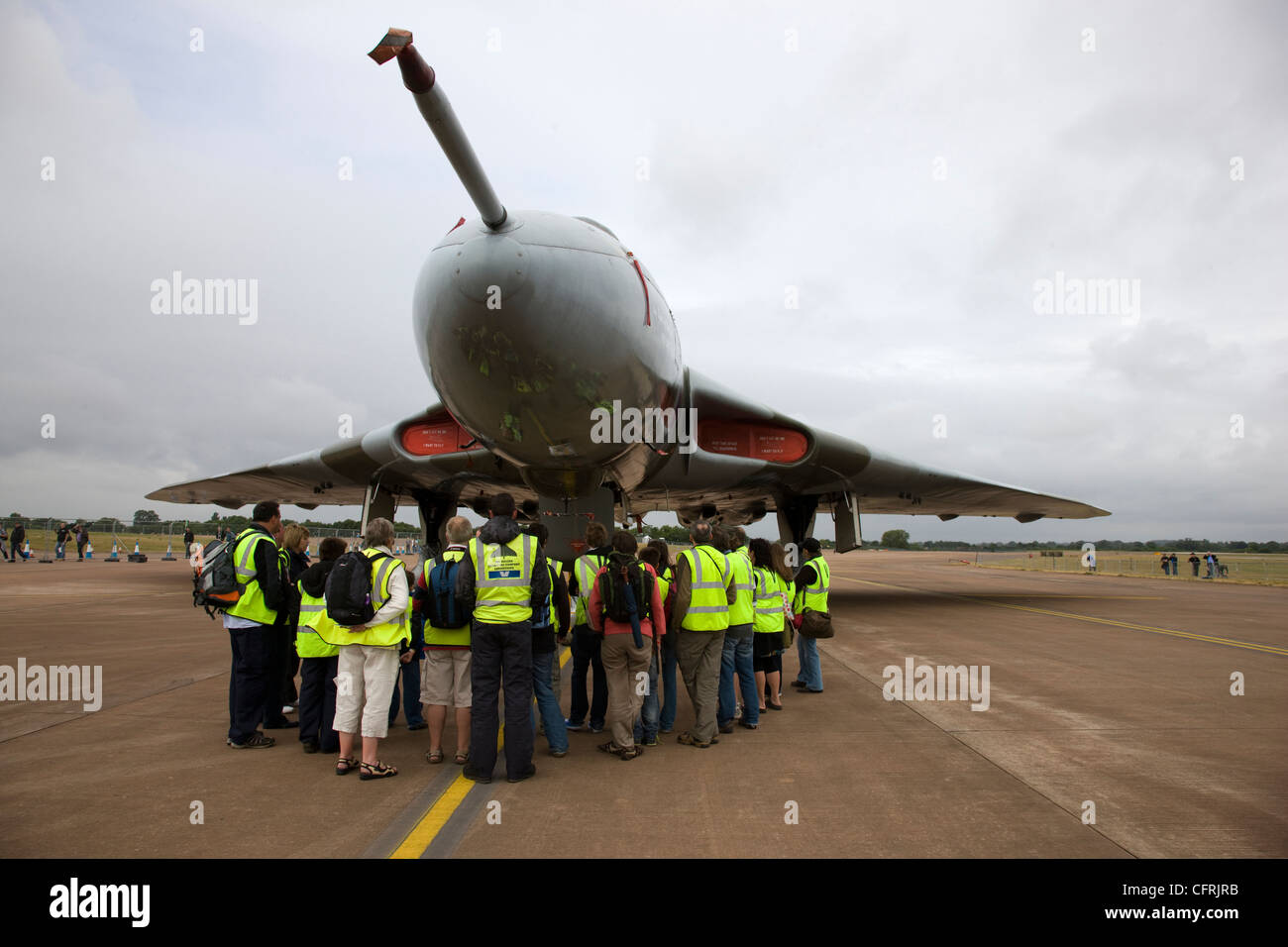Guided tour group sheltering under the wings of the Vulcan Bomber Stock ...