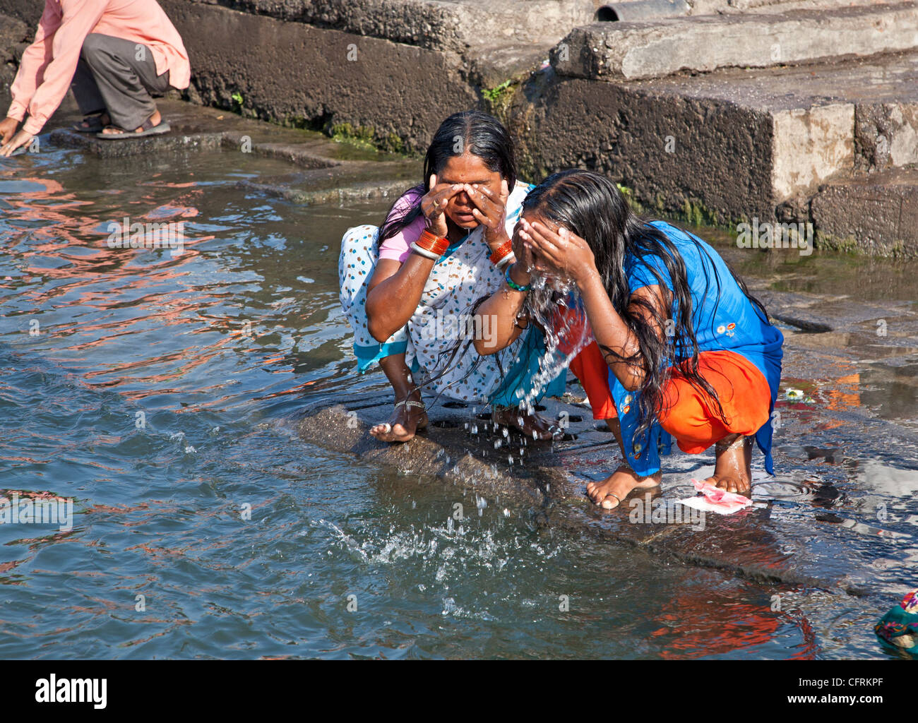 Young women making the ritual ablutions. Godavari river. Nasik. India ...