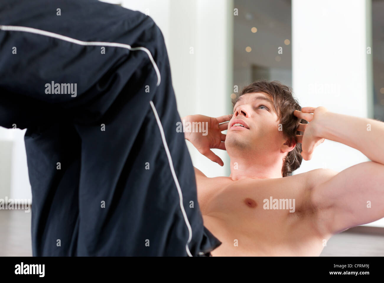 Young man exercising by doing sit-up, "sit ups” in a gym Stock Photo ...