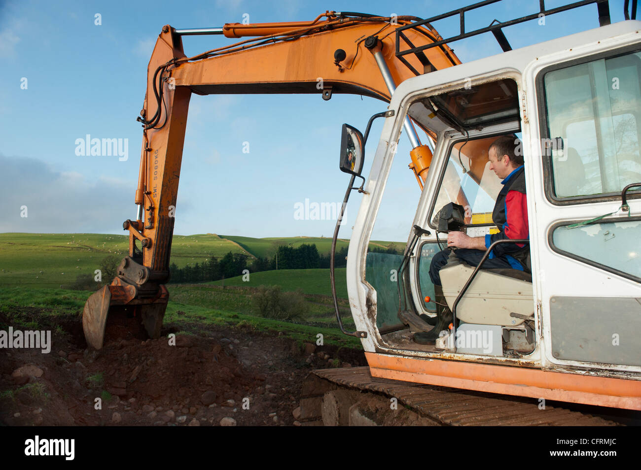 Big excavator digging stone on a hillside Stock Photo - Alamy