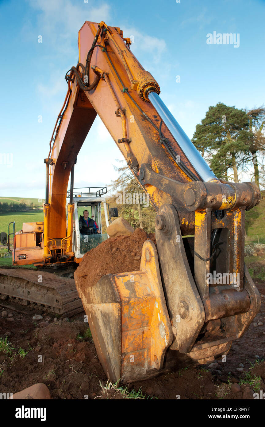 Big excavator digging stone on a hillside Stock Photo - Alamy