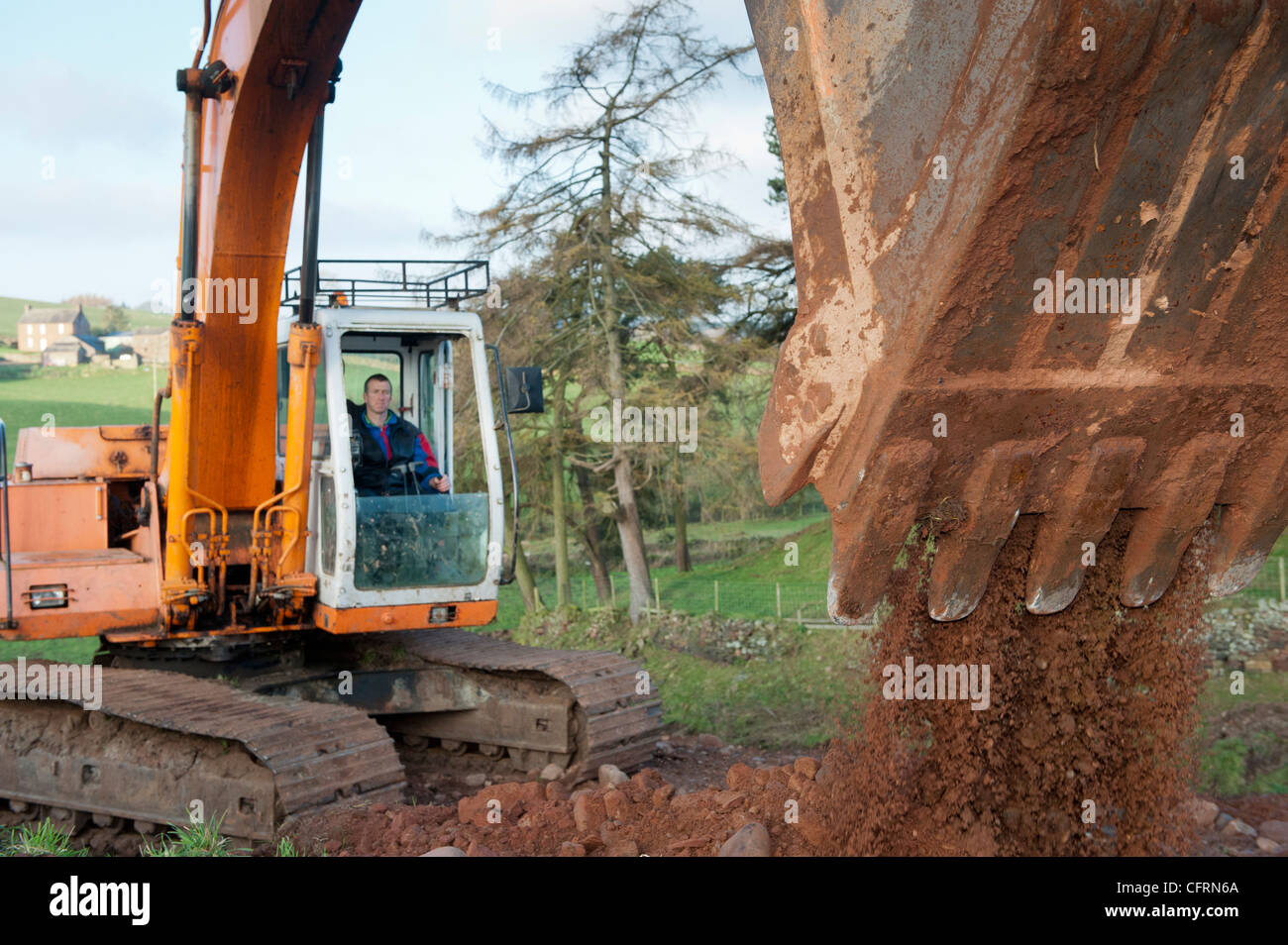 Big excavator digging stone on a hillside Stock Photo - Alamy