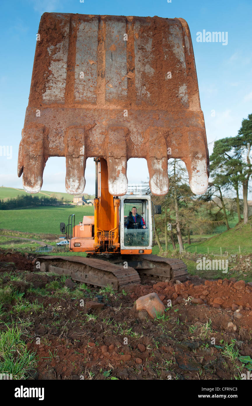 Big excavator digging stone on a hillside Stock Photo - Alamy