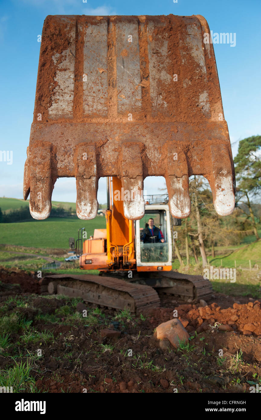 Big excavator digging stone on a hillside Stock Photo - Alamy
