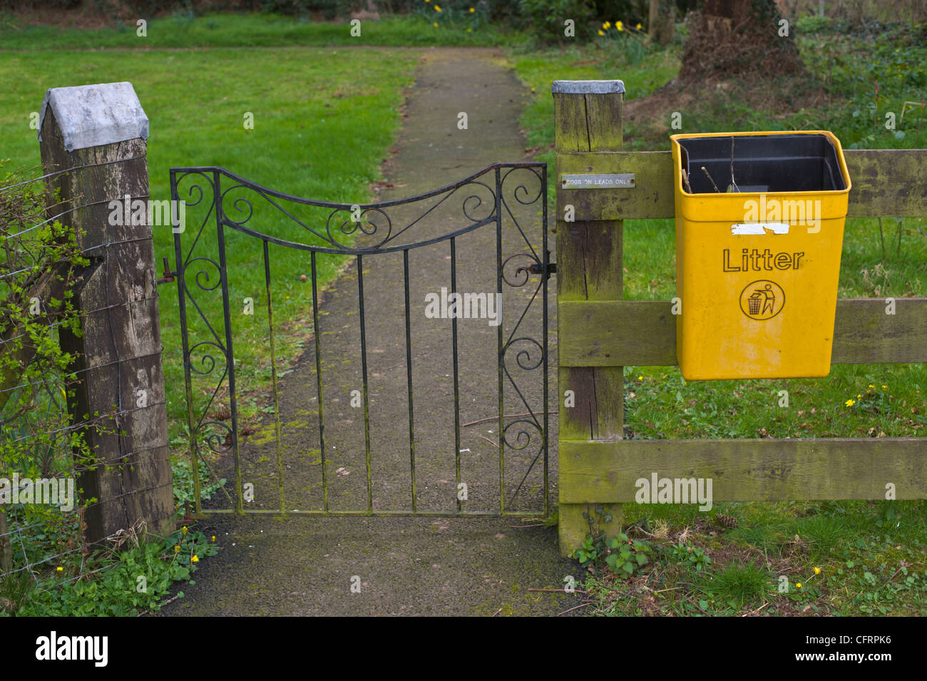 Entrance gate footpath and yellow litter bin at rural St Mary's Church ...
