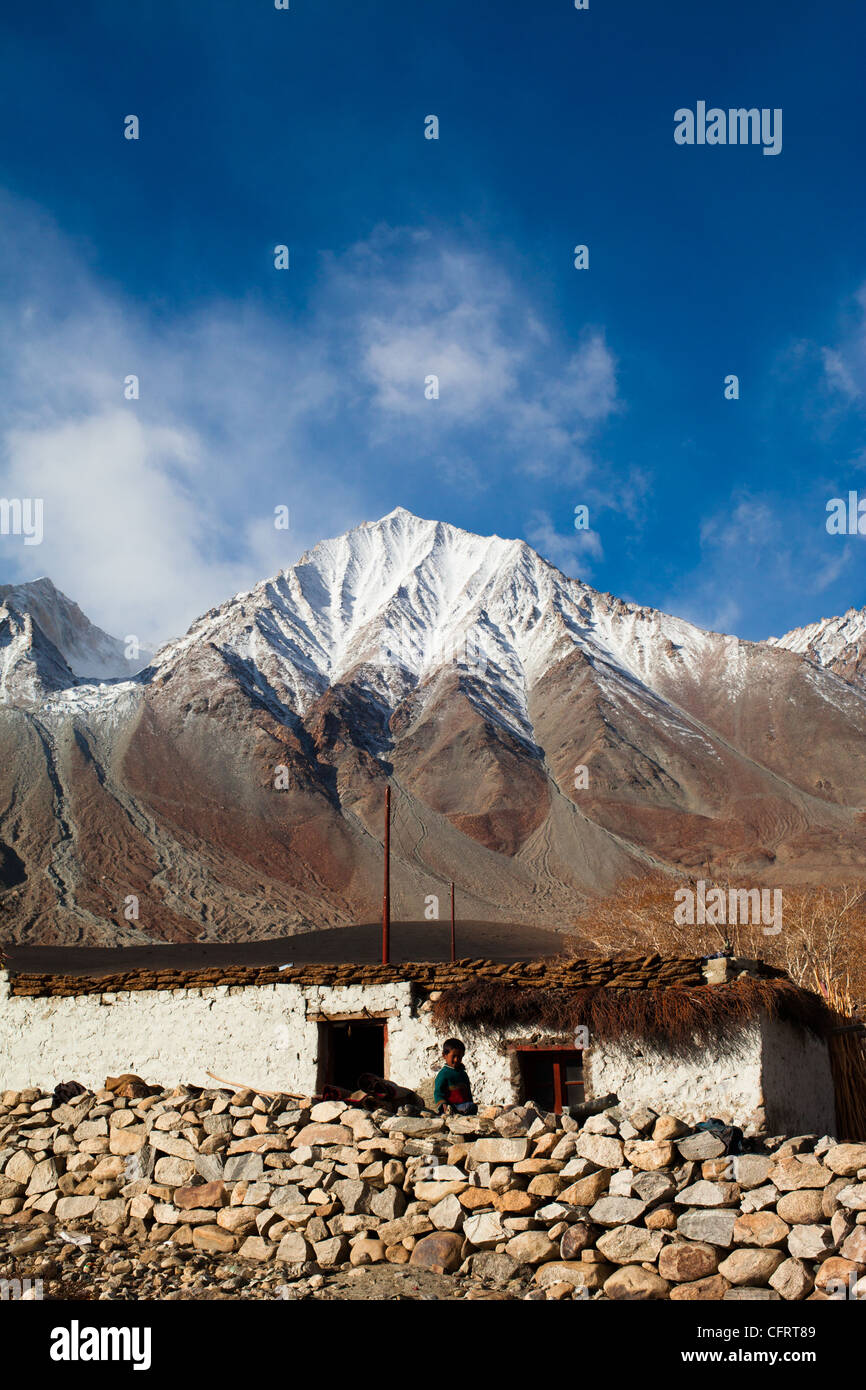 A Ladakhi house in Maan village with the snow capped peaks of the ...
