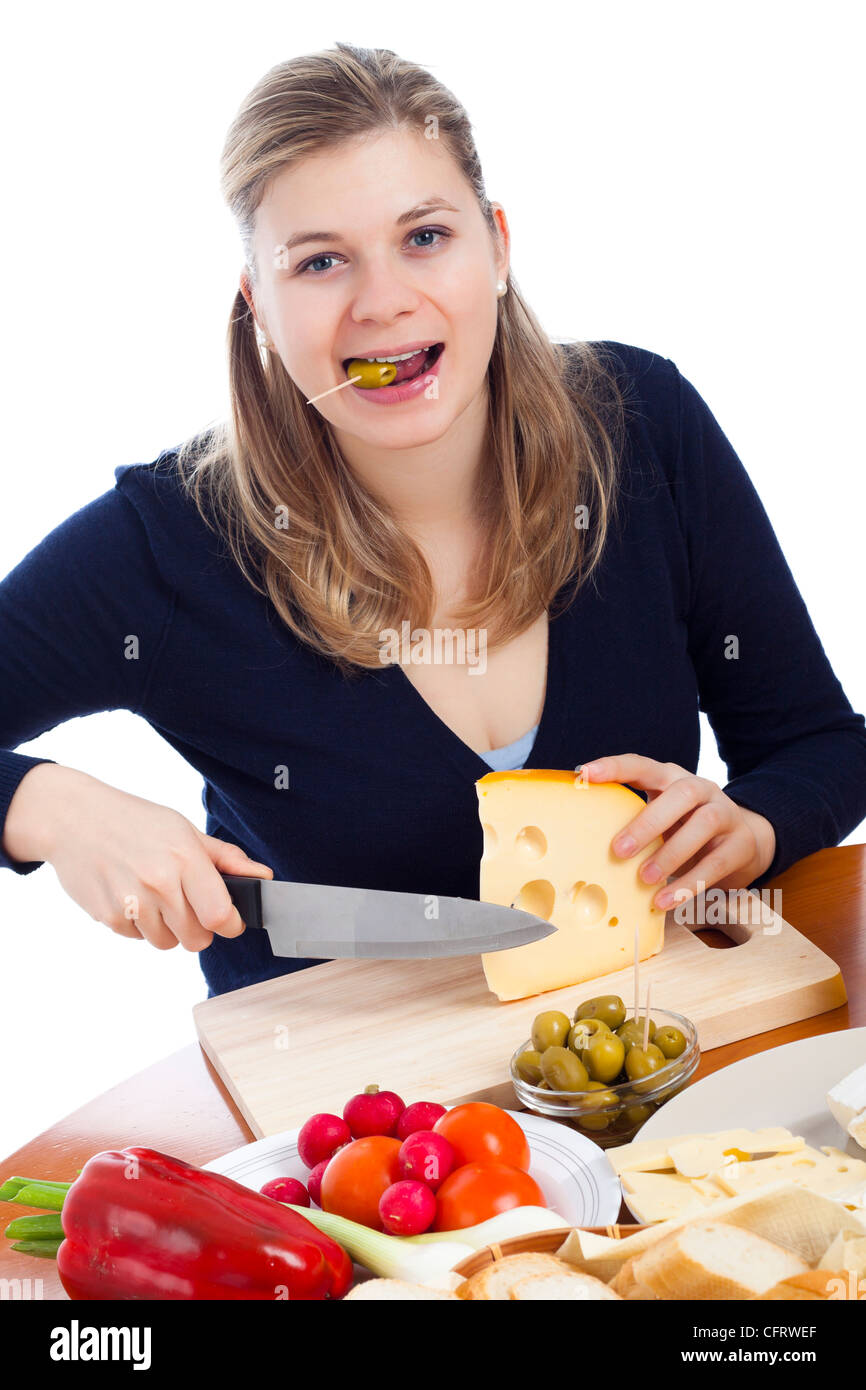 Beautiful young happy woman eating olives and cutting emmenthal cheese ...
