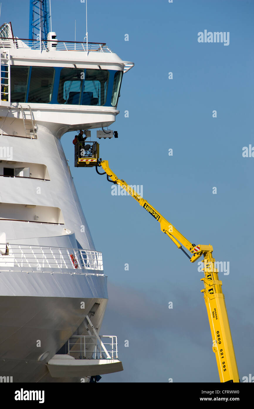 Cherry picker cleaning windows on a cruise ship docked in Southampron ...