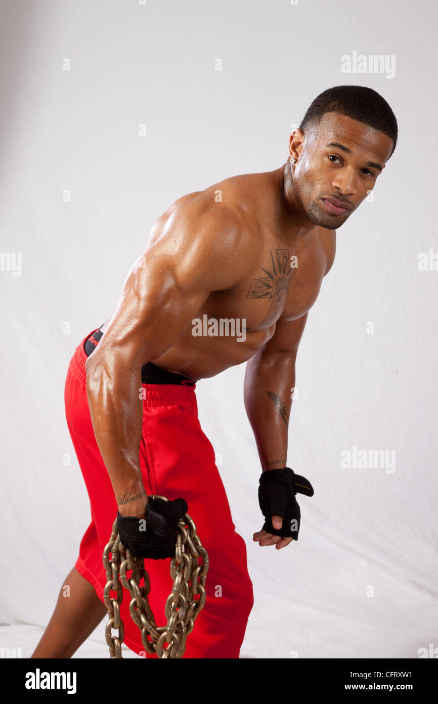 Handsome and strong young black man, working with a chain and showing ...