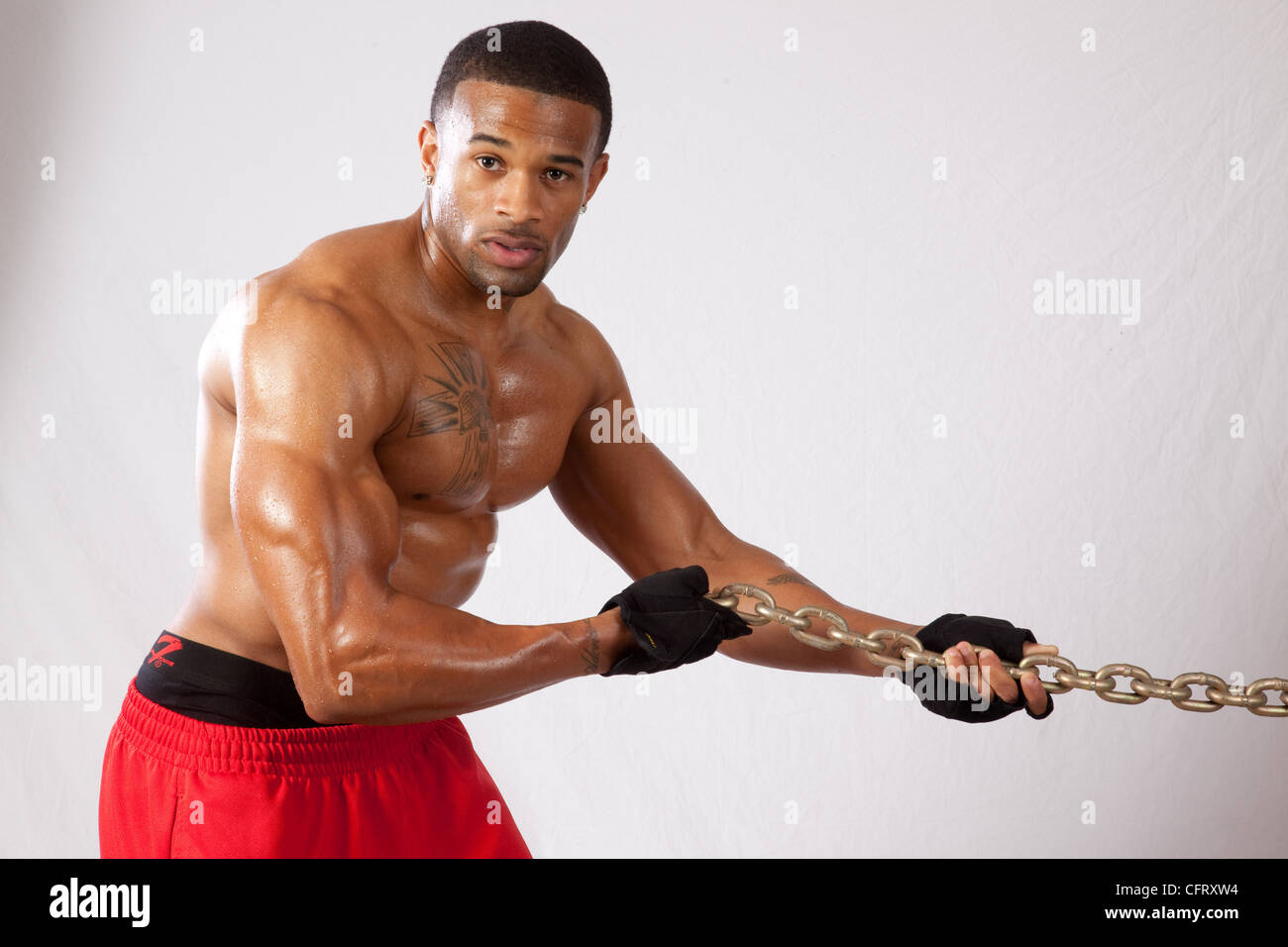 Muscular African American Black man with a heavy chain that he is ...