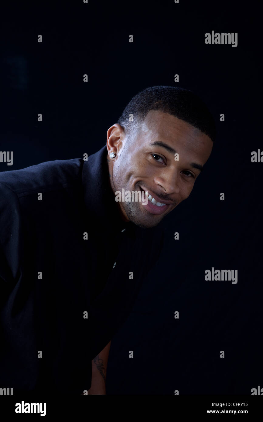 Handsome black man, with diamond ear-rings, looking at the camera with ...