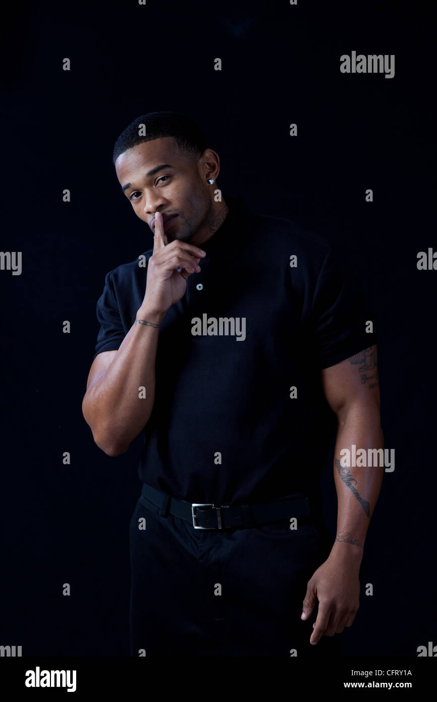 Handsome black man, with diamond ear-rings, looking at the camera from ...