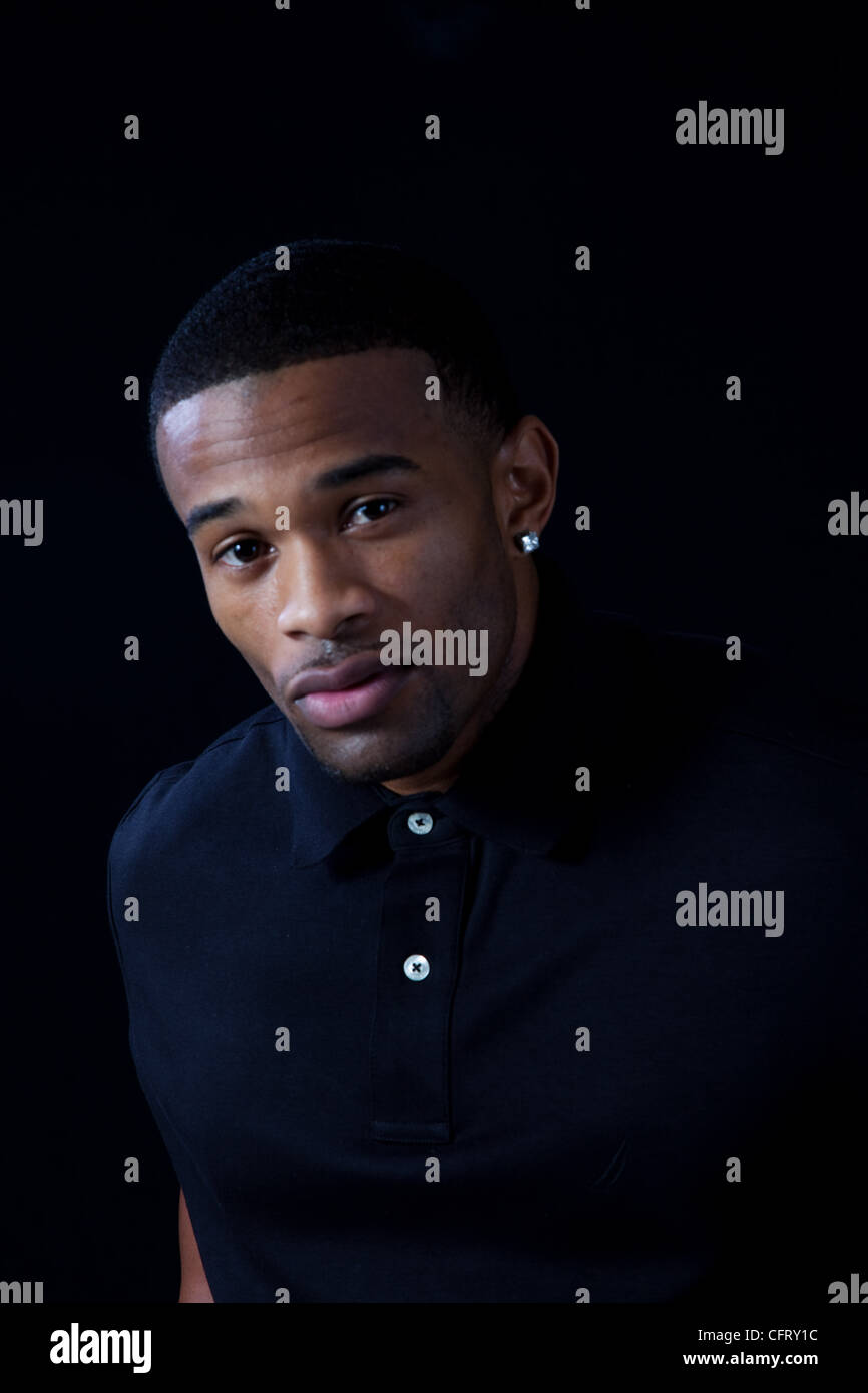 Handsome black man, with diamond ear-rings, looking at the camera from ...