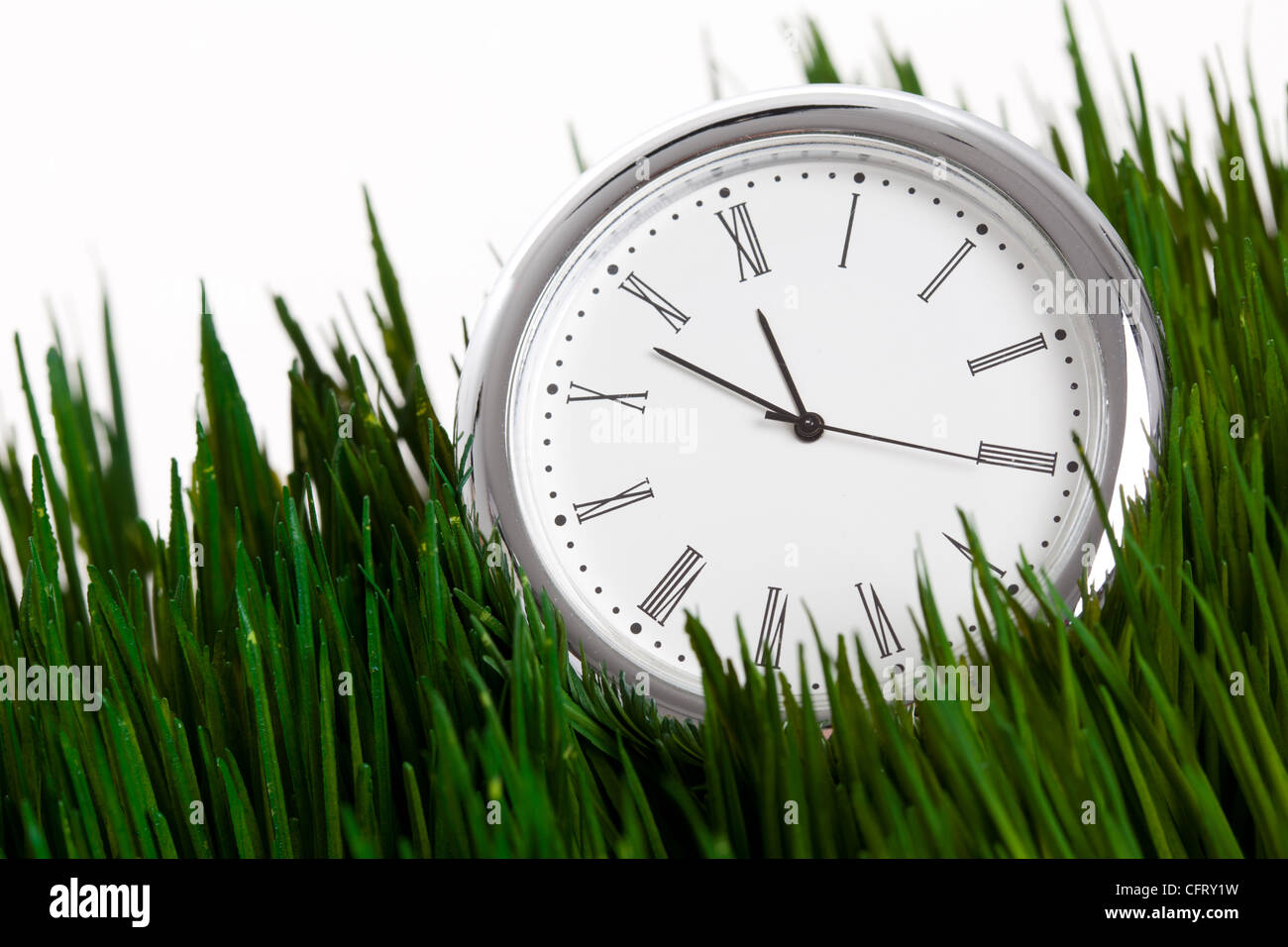 Clock and green grass close up Stock Photo - Alamy