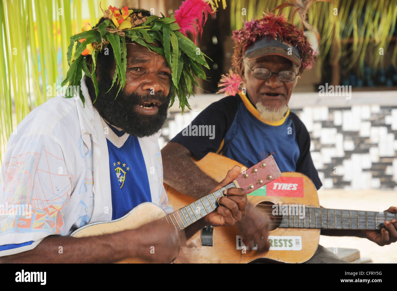 Two senior mean playing guitar for tourists Stock Photo - Alamy