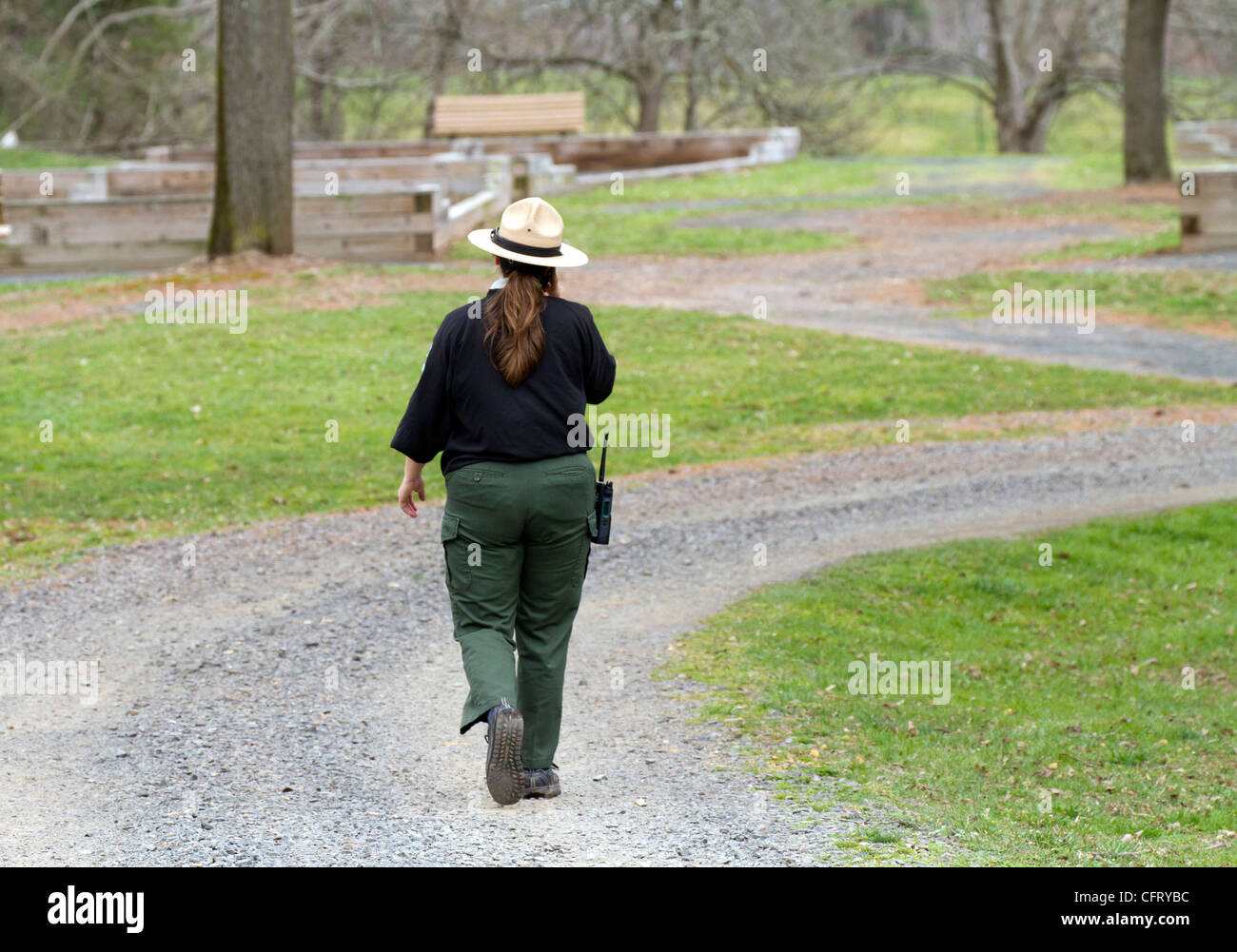 A female park ranger walking through the park Stock Photo - Alamy