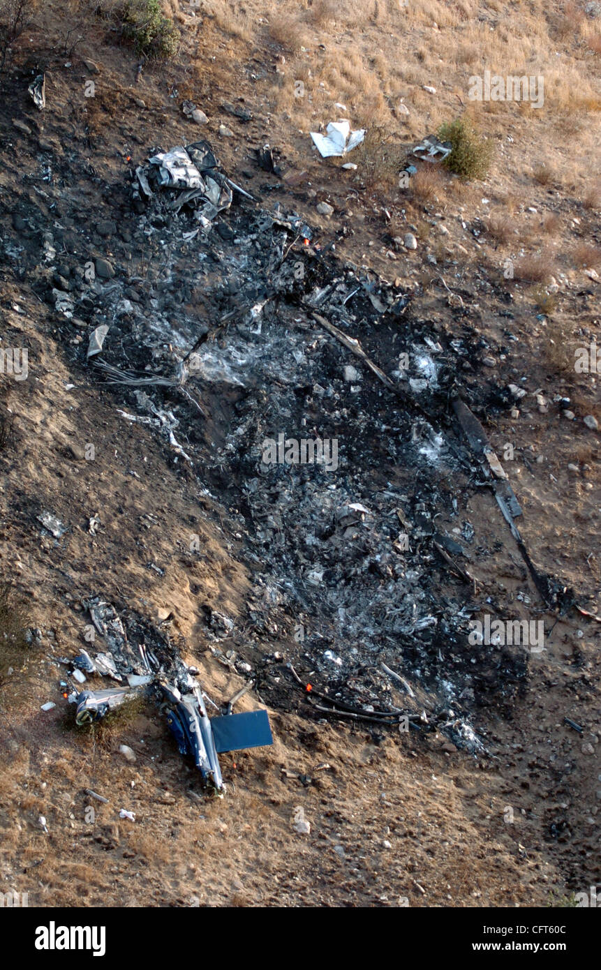 An investigator marks a debris field Monday afternoon where a Bell 412 ...