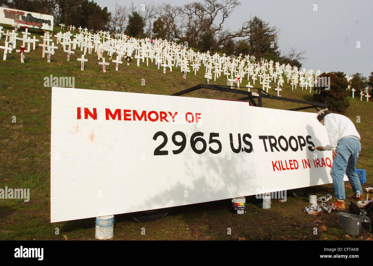 Bobbe Huetter, Walnut Creek, paints a new sign that reads, "In Memory ...