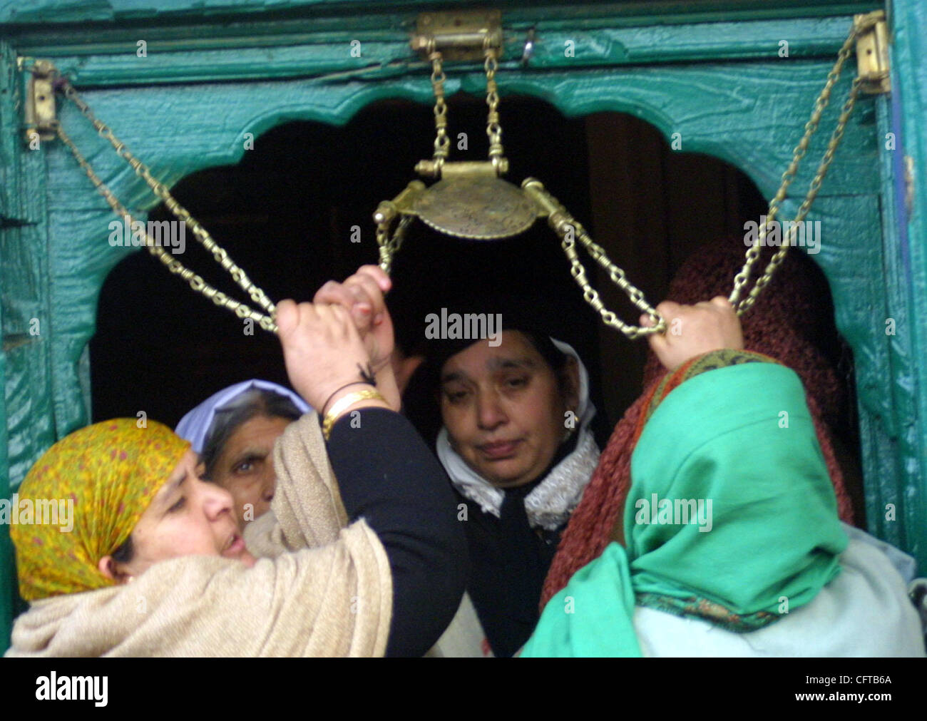 Kashmiri Muslim woman touching a chain,the symbol of blessing,at the ...