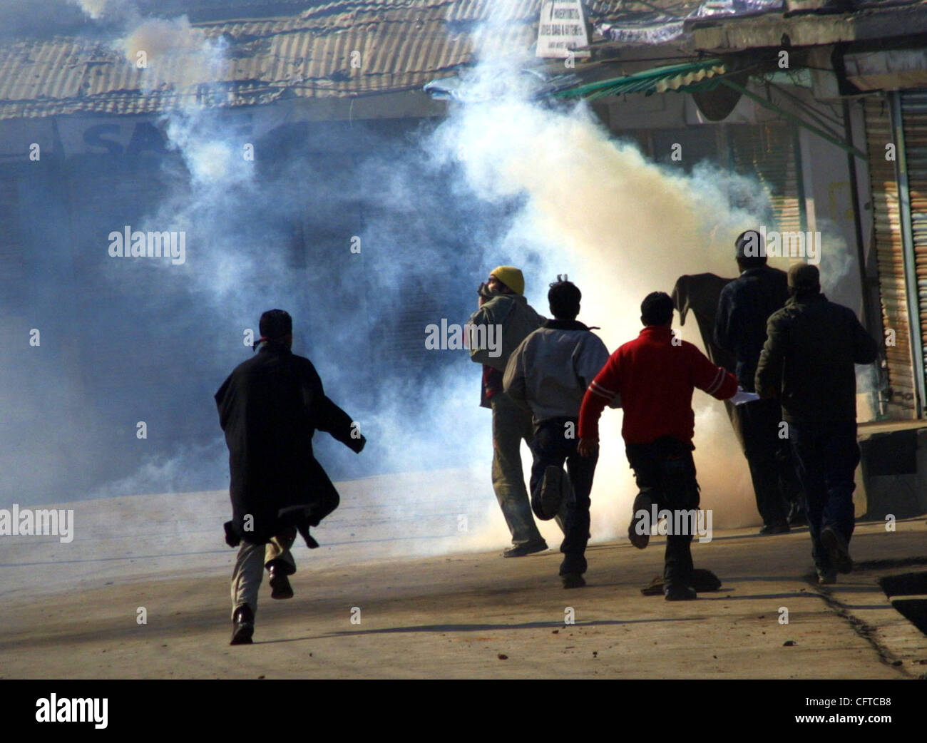 A tear smoke shell explodes near two Kashmiri protesters during a clash ...